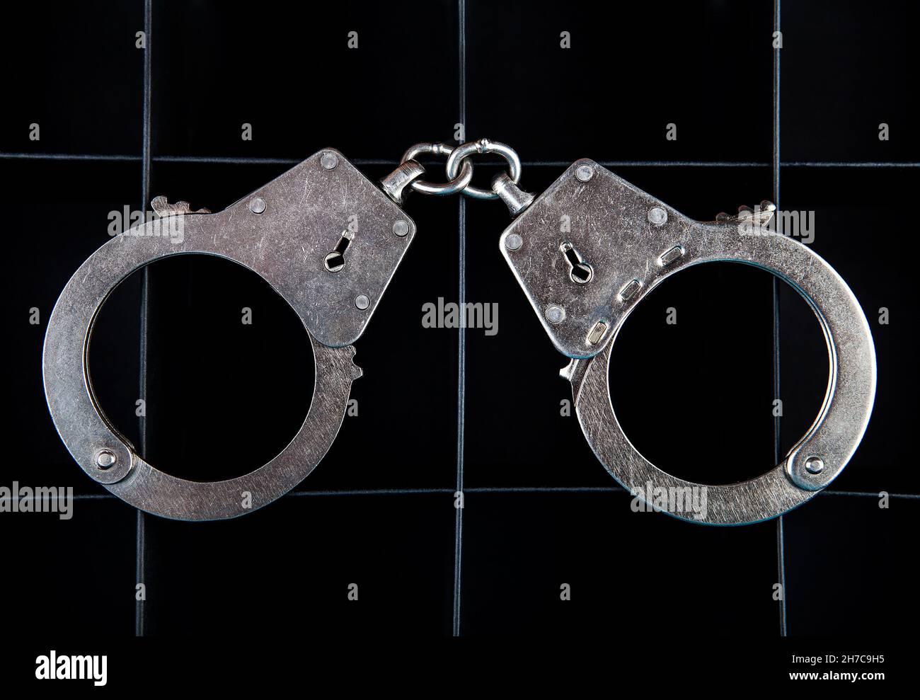 Handcuffs on the Black Background closeup Stock Photo - Alamy