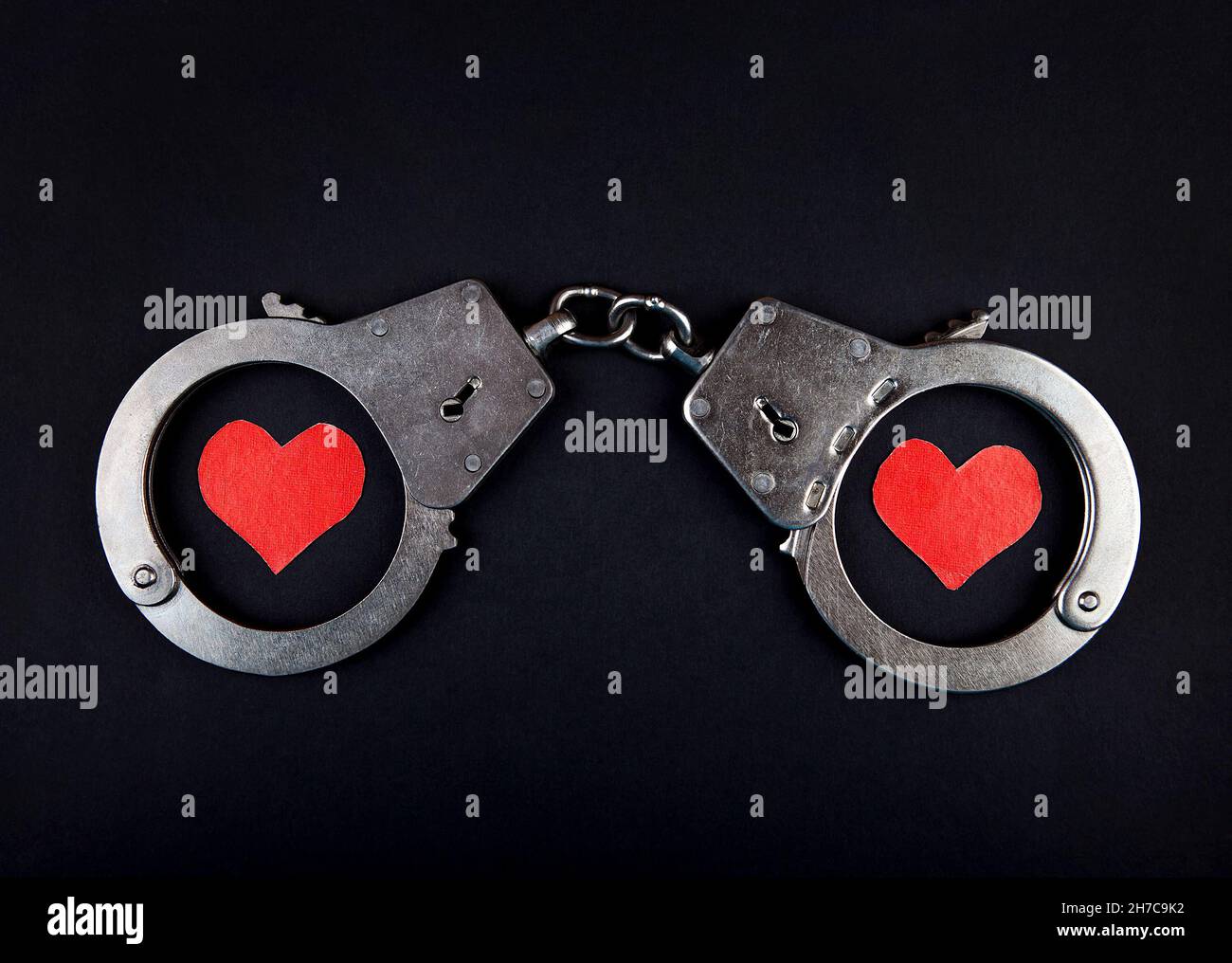 Handcuffs and Two Hearts on the Black Background Stock Photo - Alamy