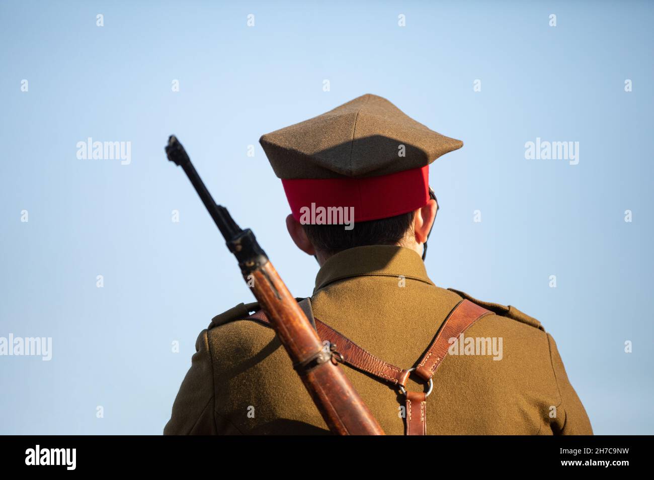 A soldier with a rifle on his back against a blue sky Stock Photo - Alamy