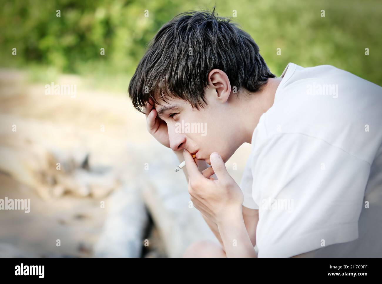 Sad Young Man with Cigarette on the Nature Background Stock Photo - Alamy