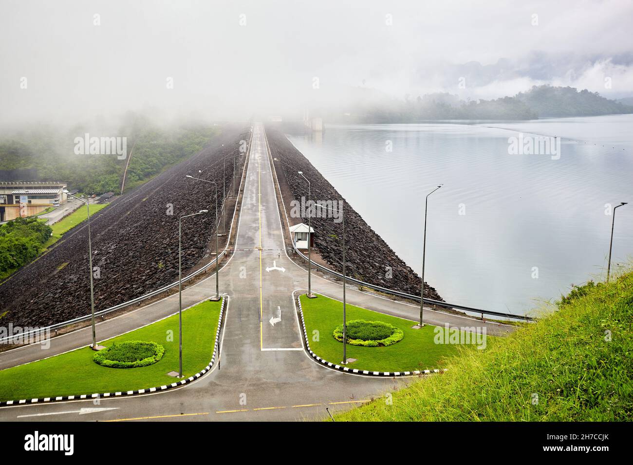 A beautiful scene of asphalt road with fog in the dam Stock Photo - Alamy