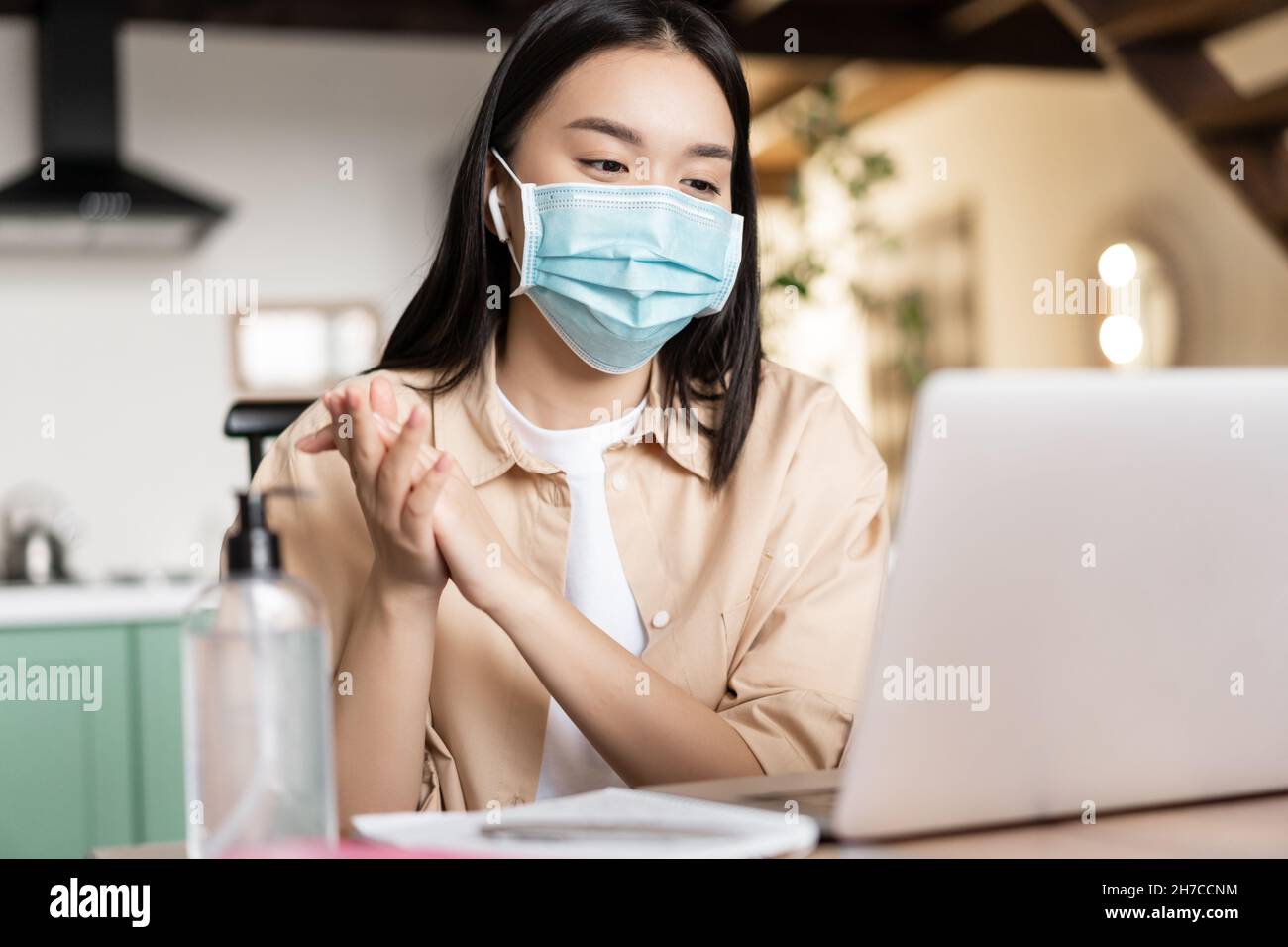 Asian woman washing hands with hand sanitizer, wearing face medical ...