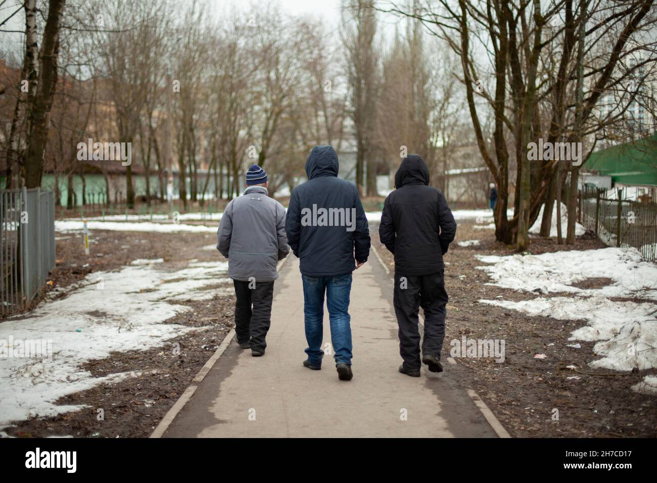 Three men walk down the road. Residents of Russia. Pensioners walk ...