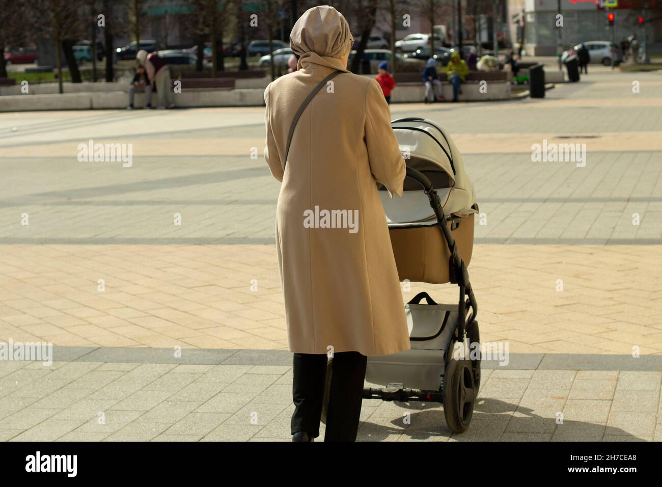 Mother with a stroller on the street. Walk with the baby in the fall. A ...