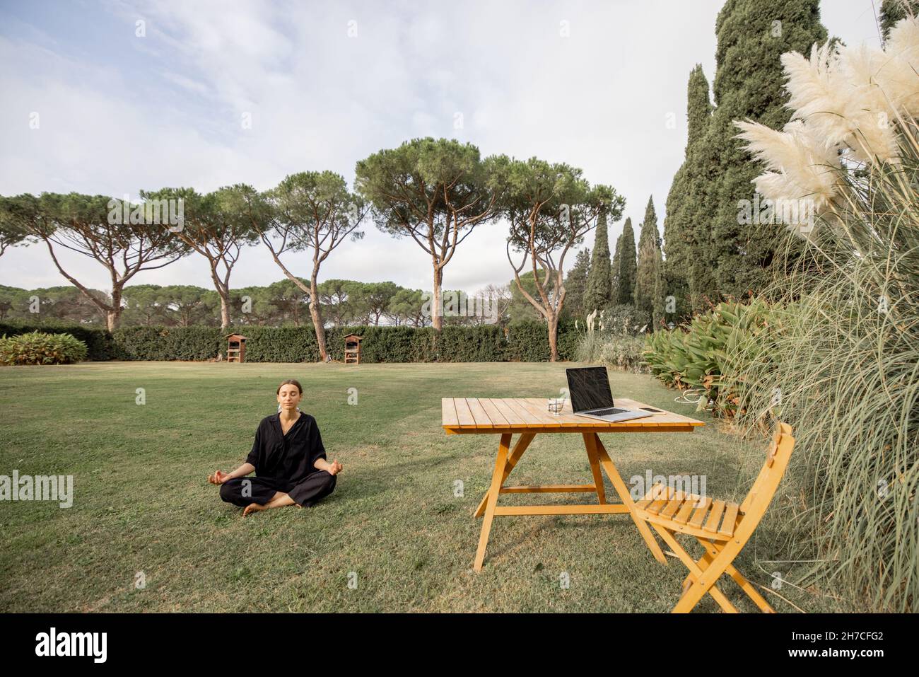 Girl meditating and practicing yoga on green lawn Stock Photo - Alamy