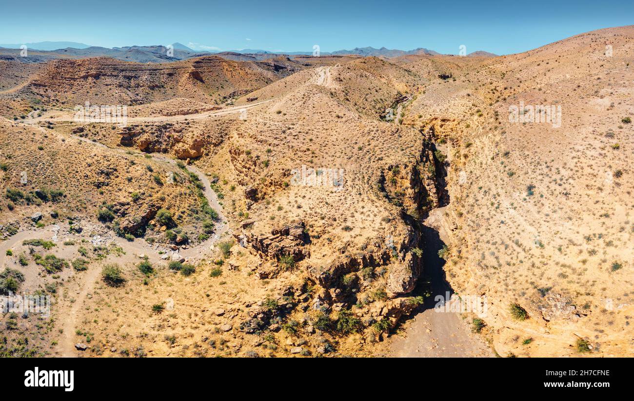 Aerial view of dry canyon in the desert terrain with red rocks in a ...