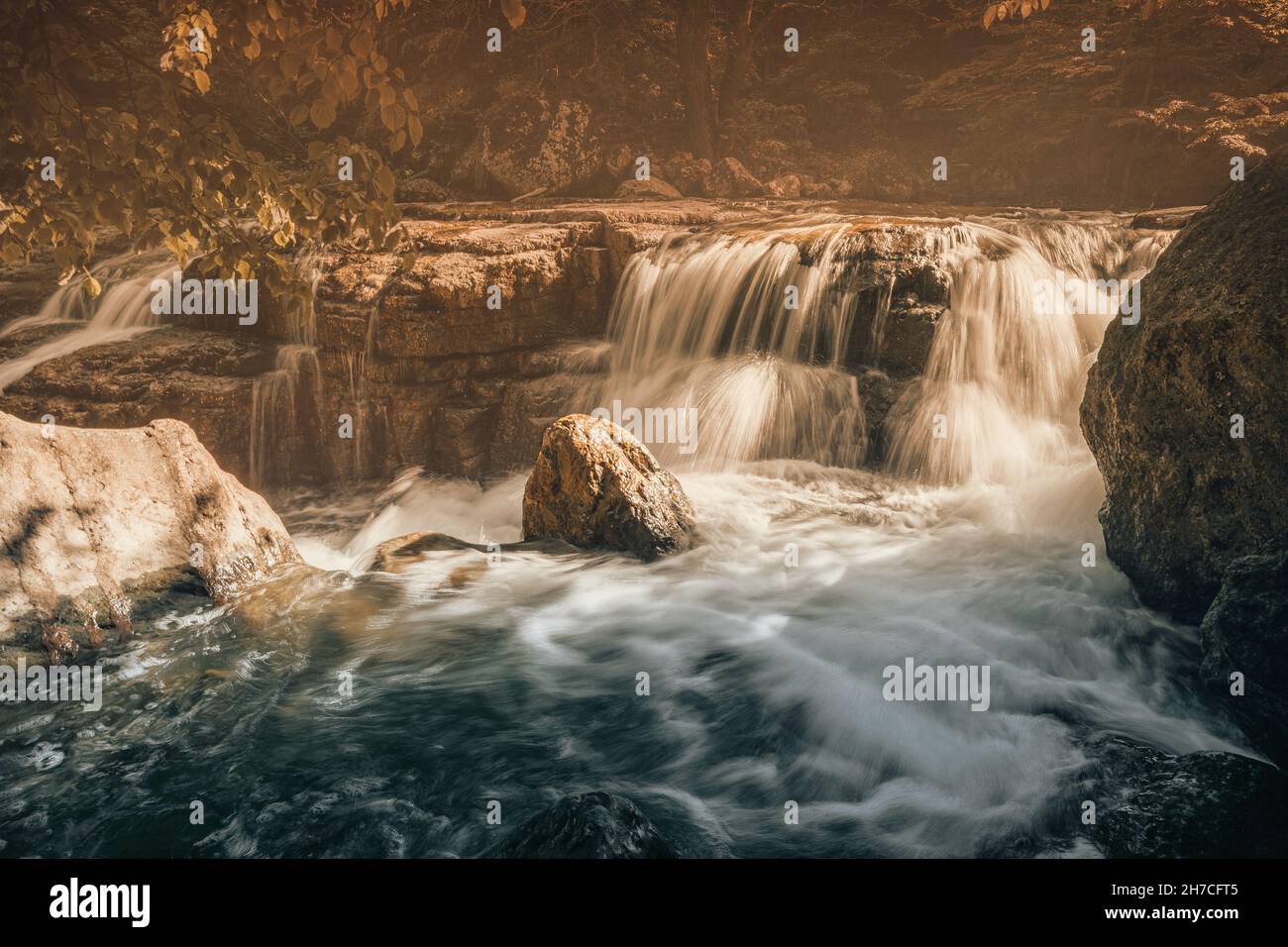 A rapid river flow formed a threshold and a small waterfall on the ...