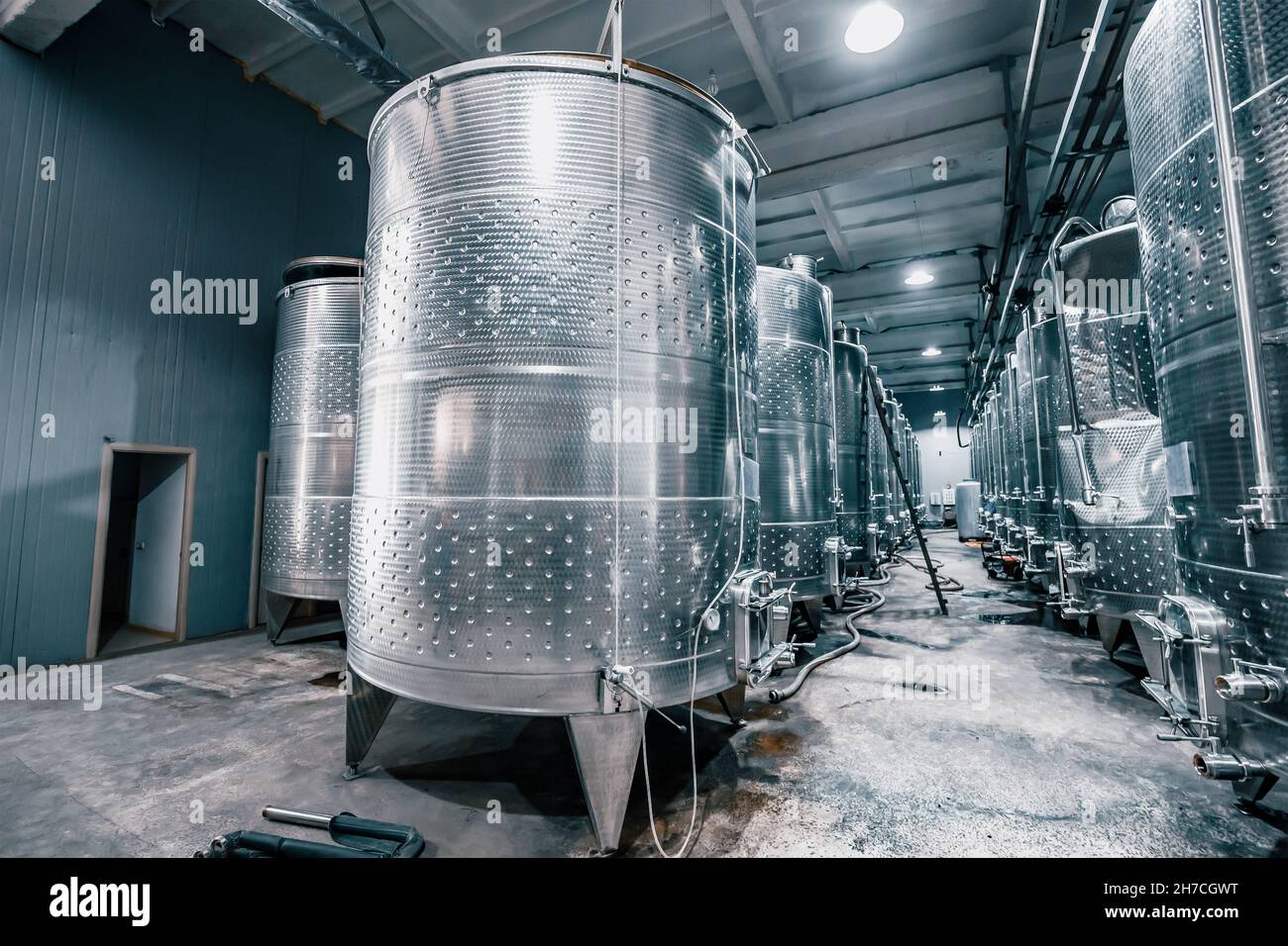 Large metal vats in which wine or beer is fermented at the factory at ...