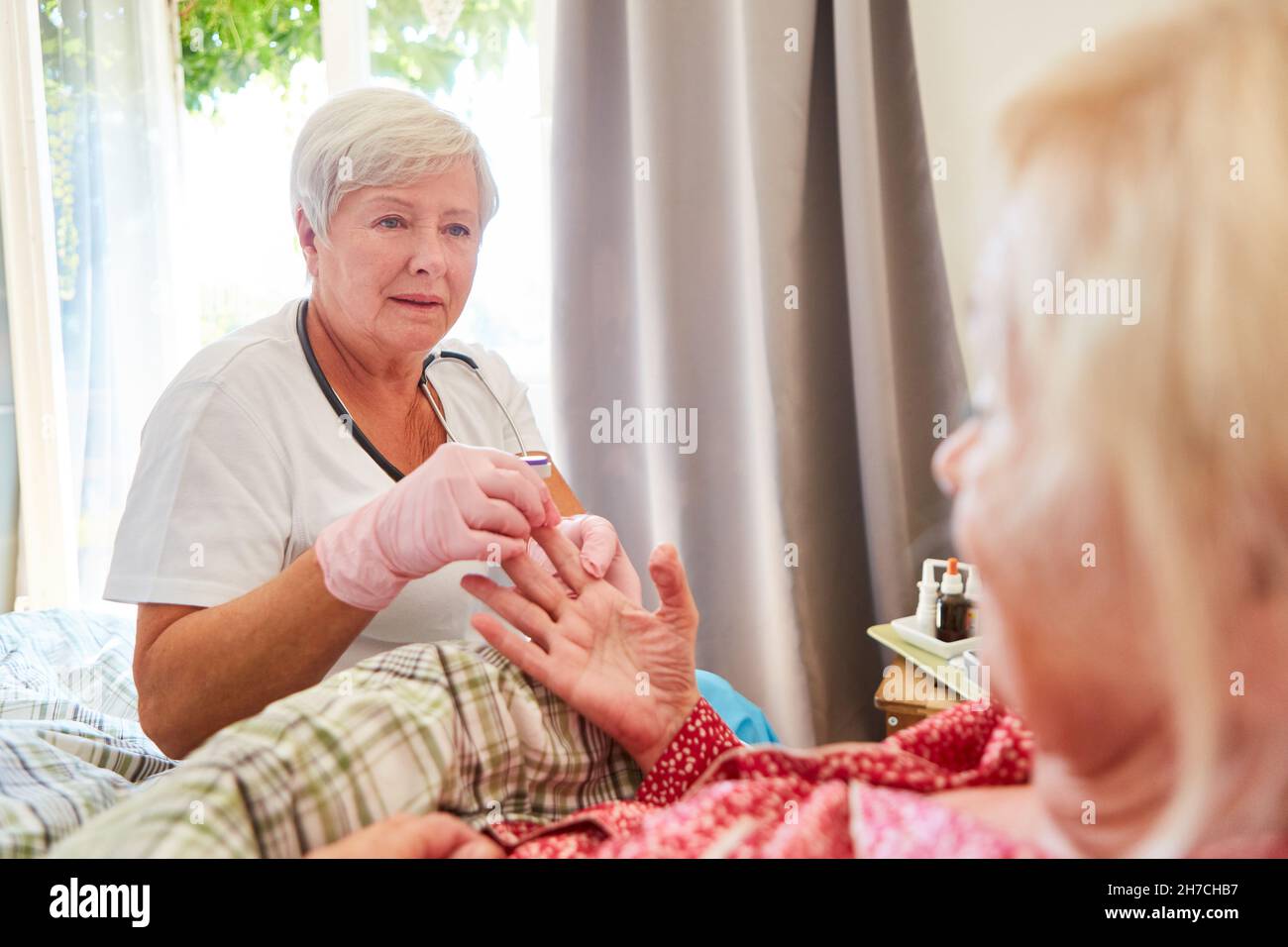 Geriatric nurse or nursing service woman caring for a patient in a ...