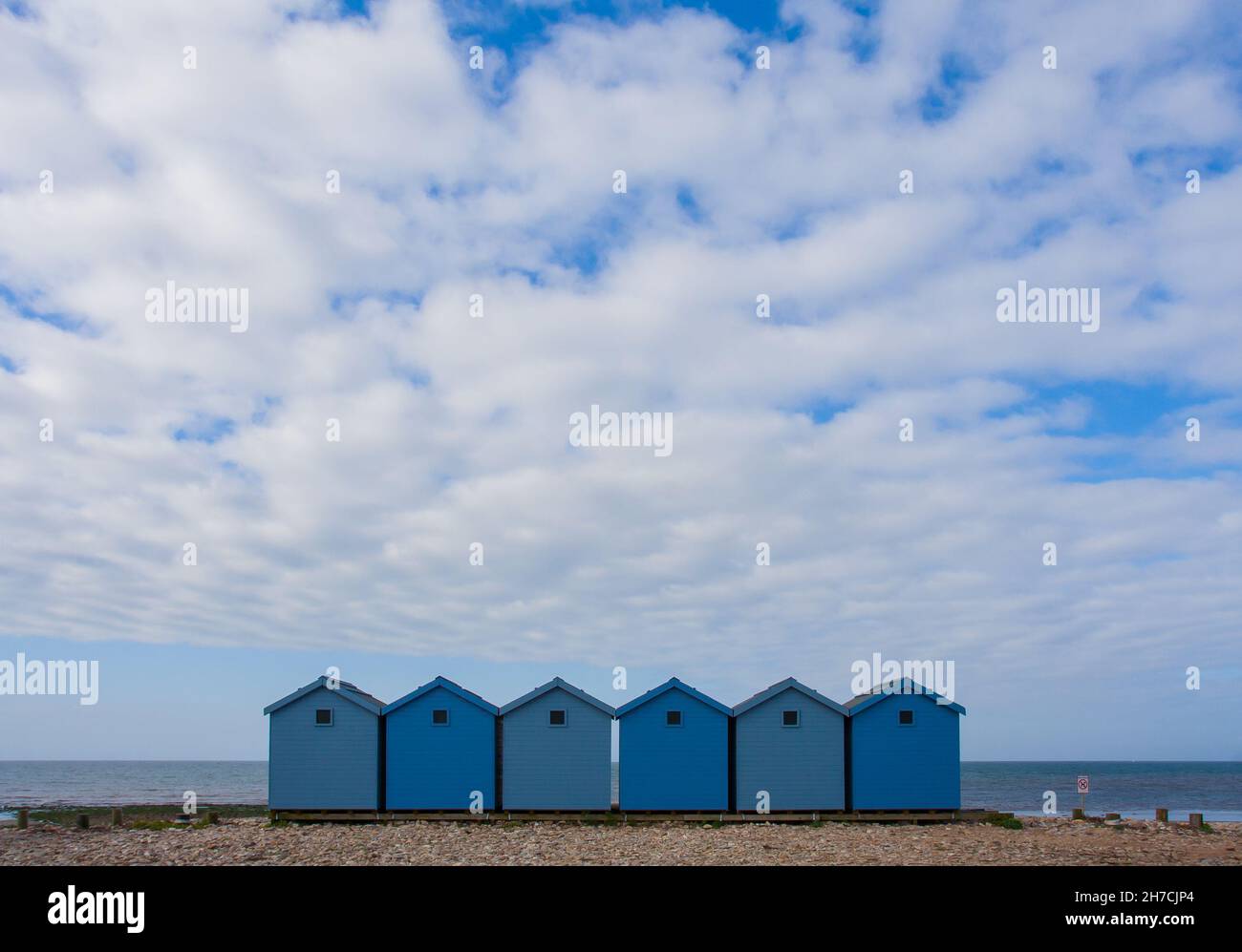 Row of blue beach huts on a beach in Southern England Stock Photo - Alamy