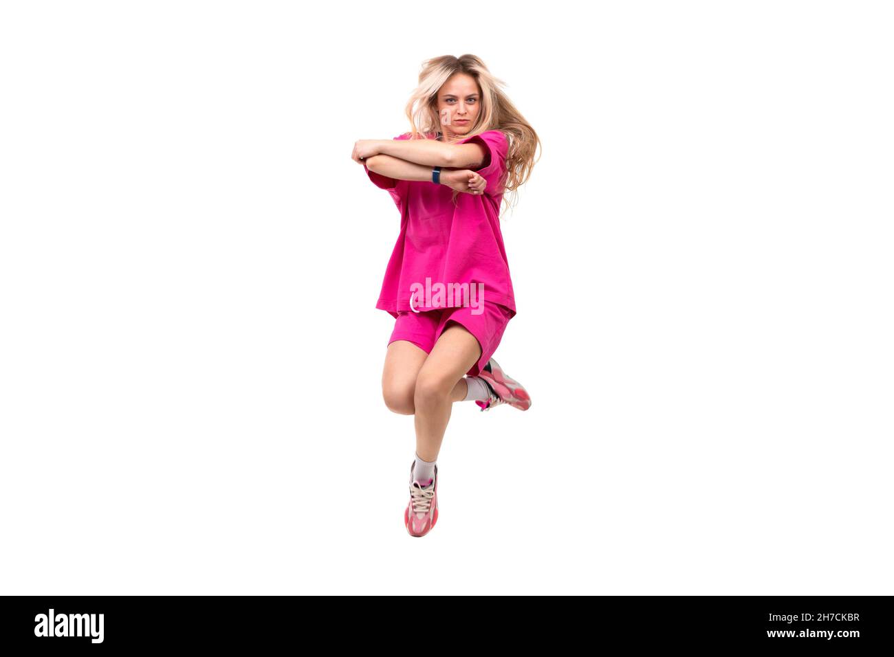 dancing blonde in a pink tracksuit and short shorts on a white ...