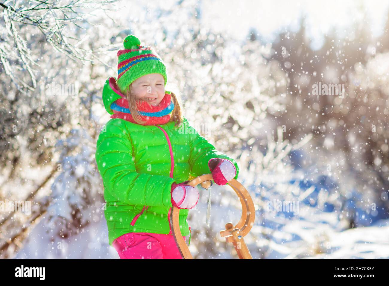 Little girl enjoying a sleigh ride. Child sledding. Toddler kid riding ...