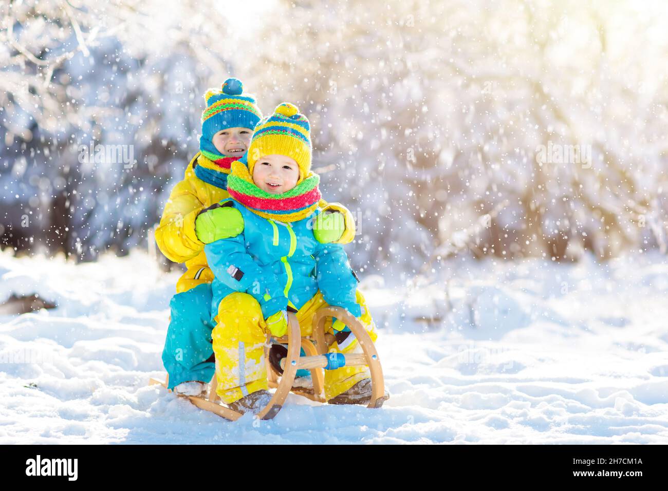 Little girl and boy enjoying sleigh ride. Child sledding. Toddler kid ...