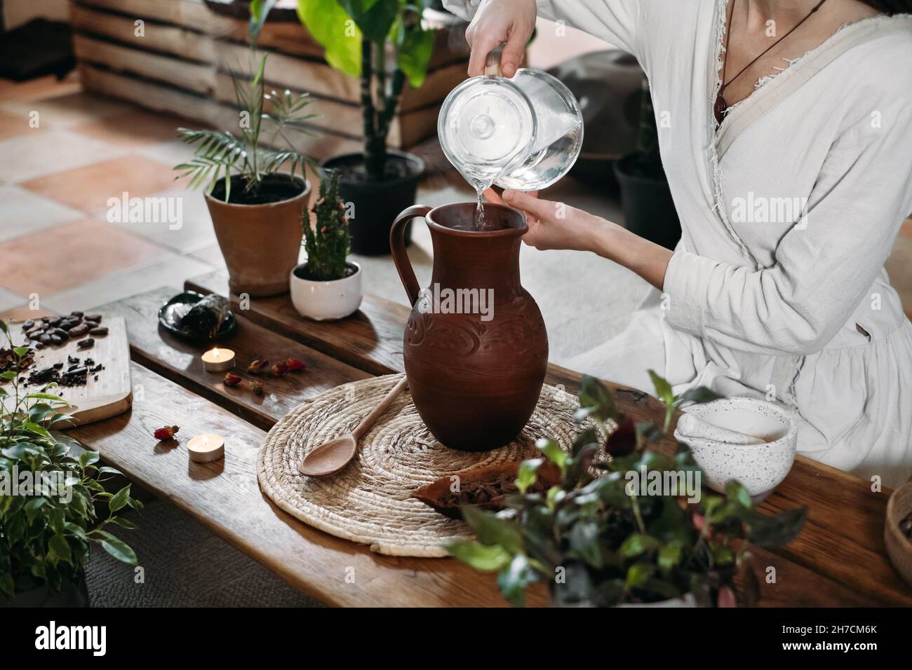 Pouring water into jug with cacao. Preparing ceremonial cocoa in ...