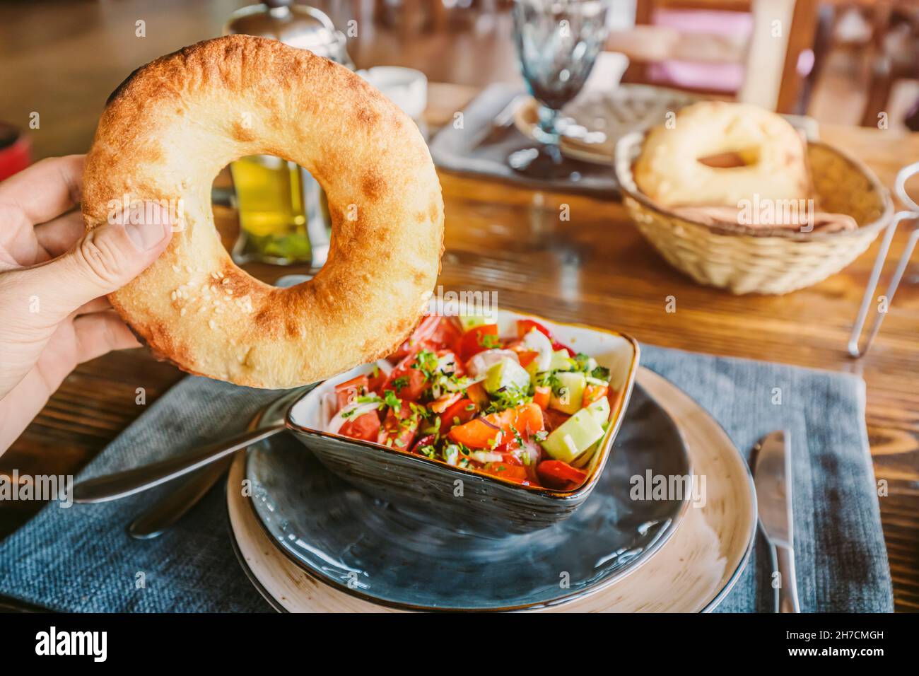 Round bagel bun with a hole on the background of a salad plate in a ...