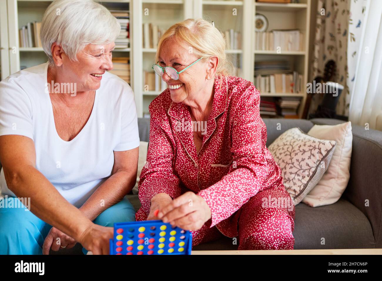 Two old women play four wins as a retiree in their free time as a fun ...
