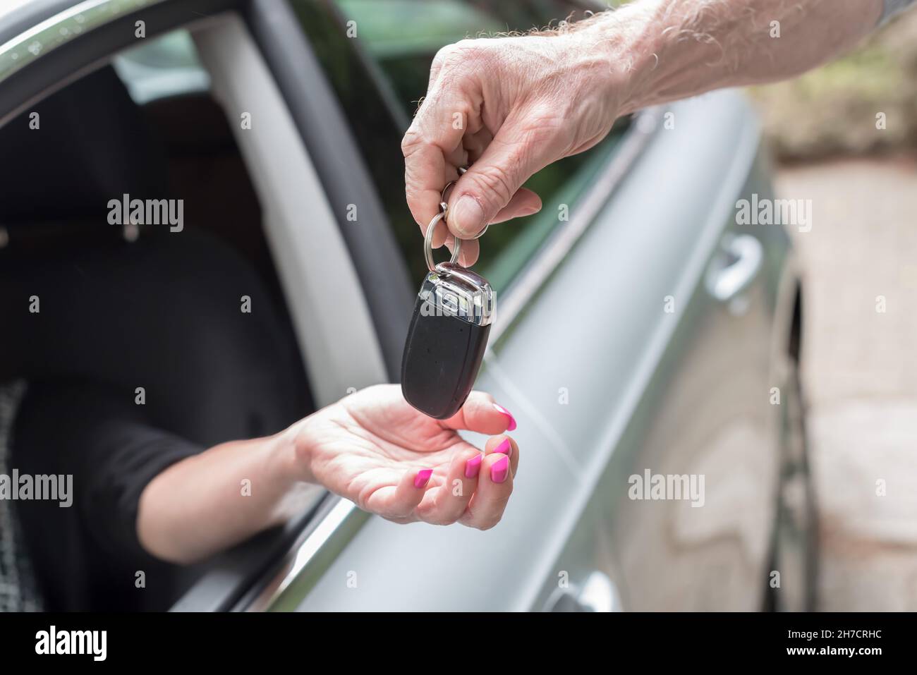 Man handing another person automobile keys Stock Photo - Alamy