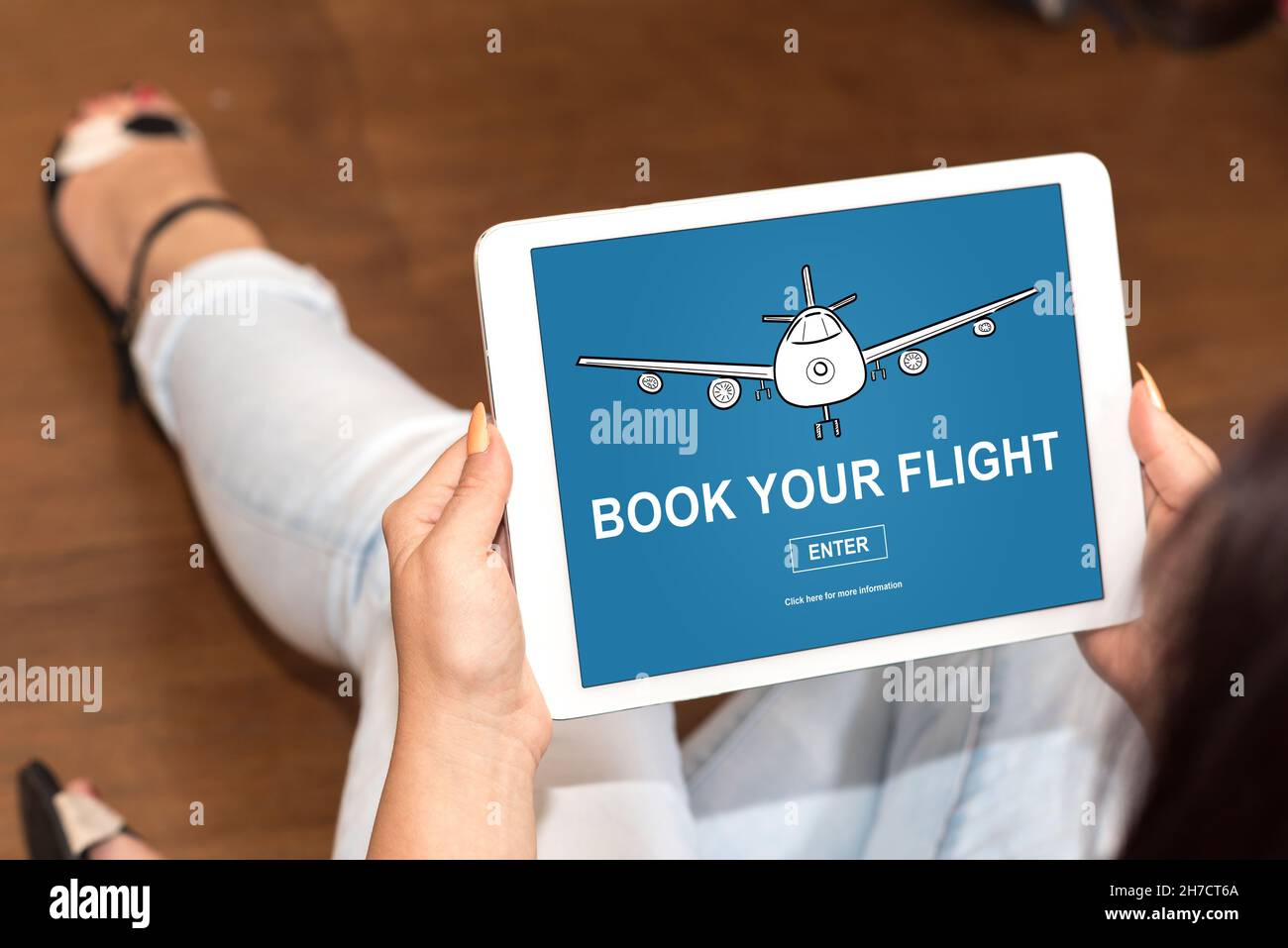 Tablet screen displaying a flight booking concept Stock Photo - Alamy