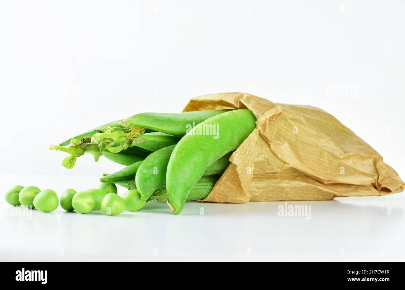 Closeup shot of garden peas in a kraft paper bag isolated on white ...