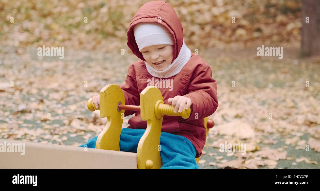 Small, cute child rides on a swing in the yard on a walk Stock Photo ...