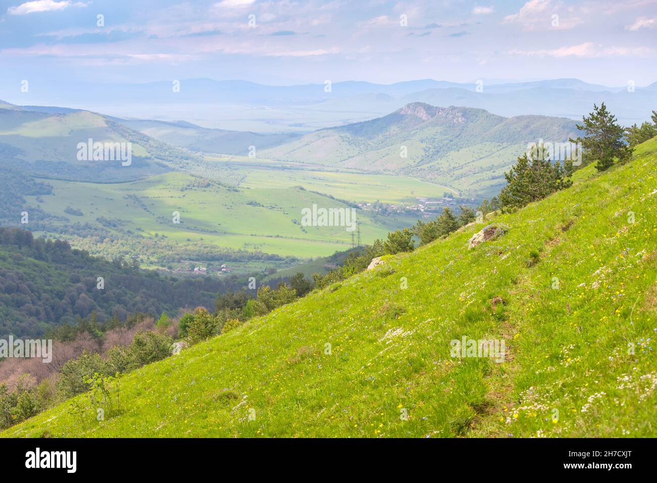 A barely noticeable path leads along a grassy hillside in the ...