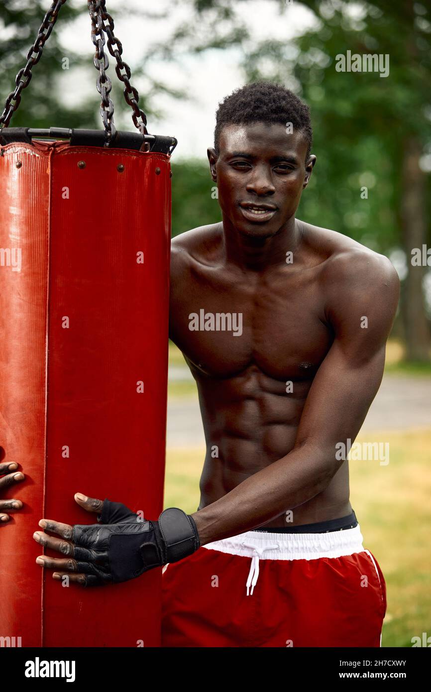 Front view of muscular black boxer punching towards camera with a deep ...