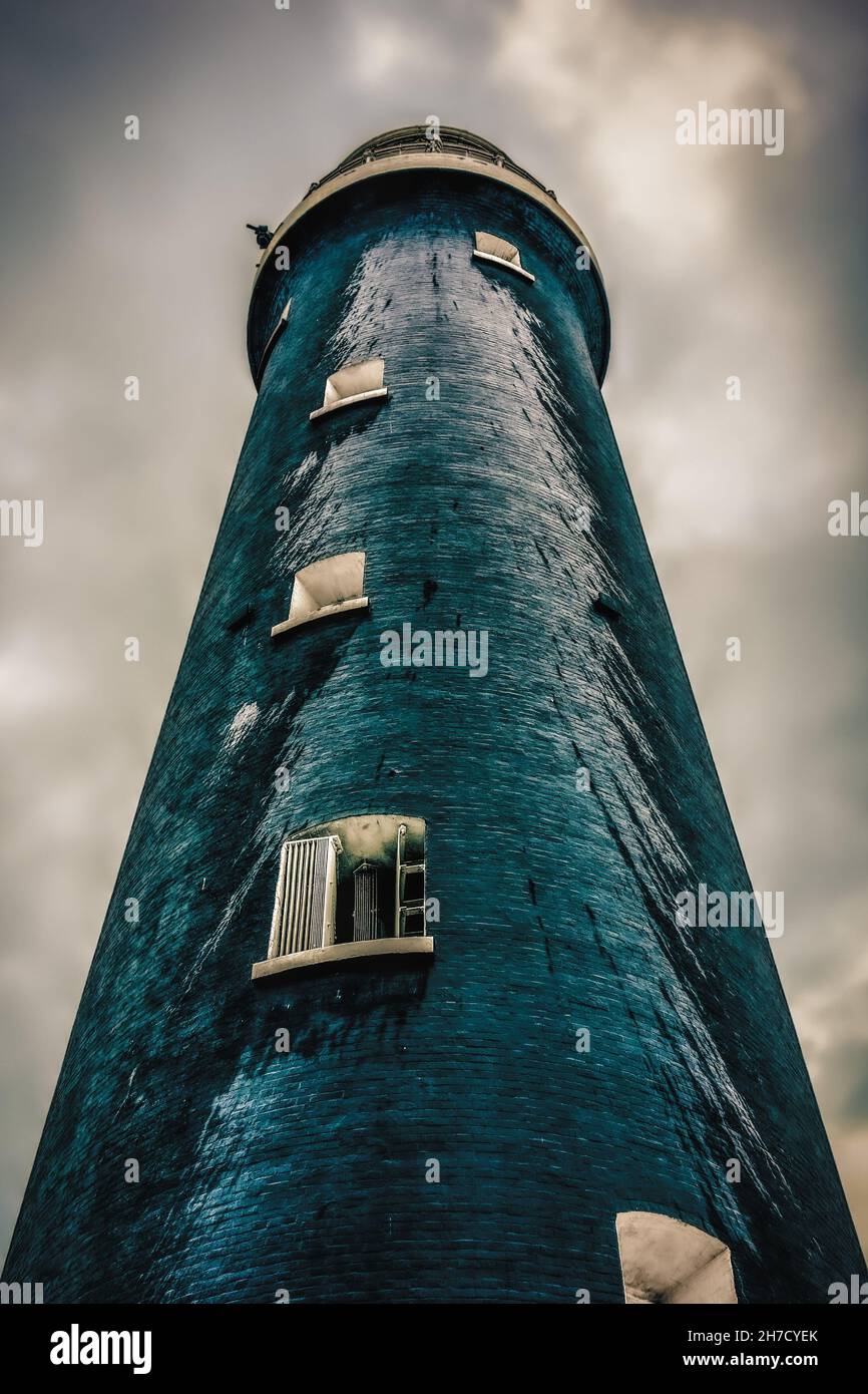 Wide-angle view looking up of a lighthouse in a dark and moody style ...