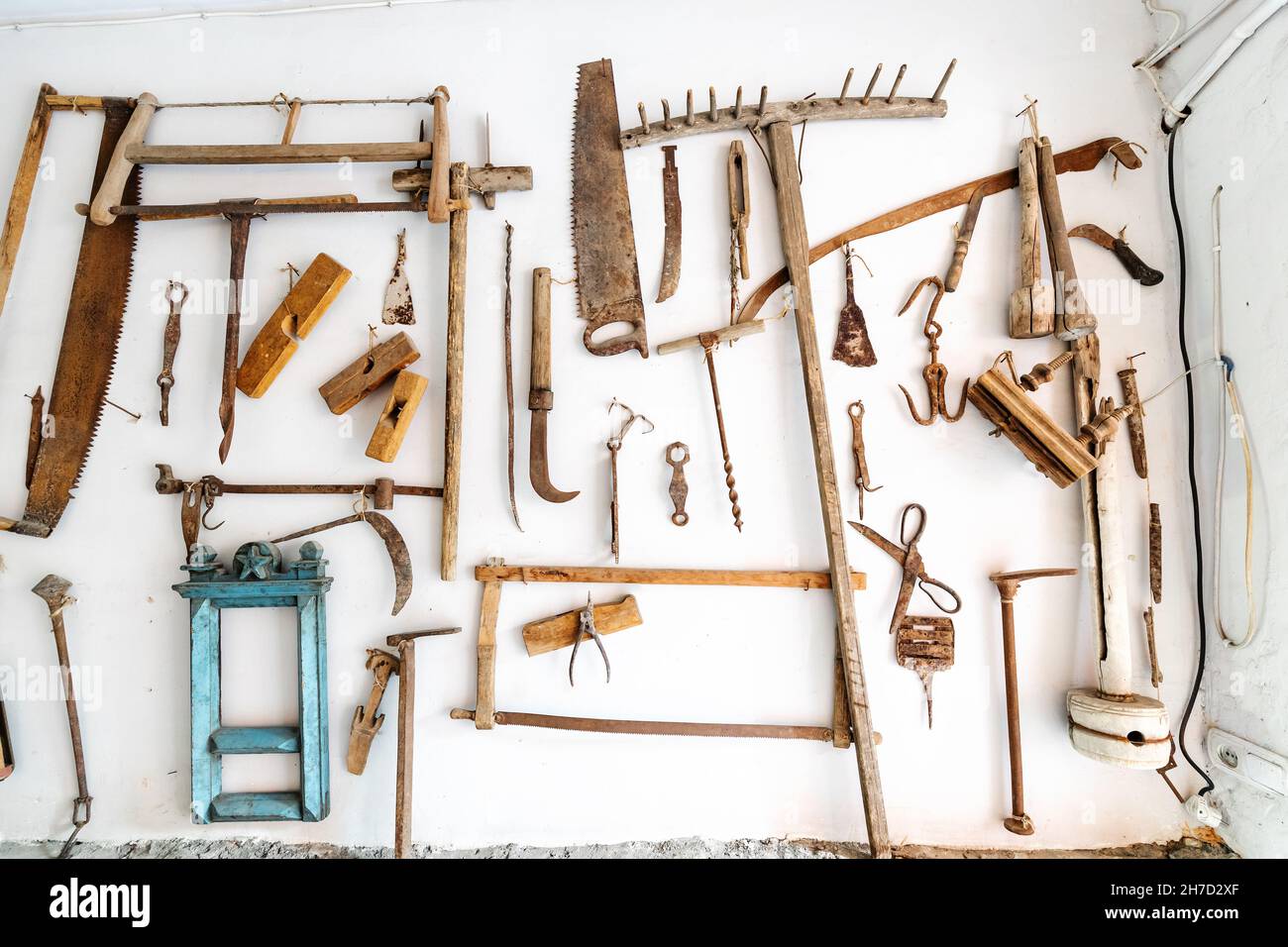 A lot of ancient wooden rural tools on the wall in the village Stock ...