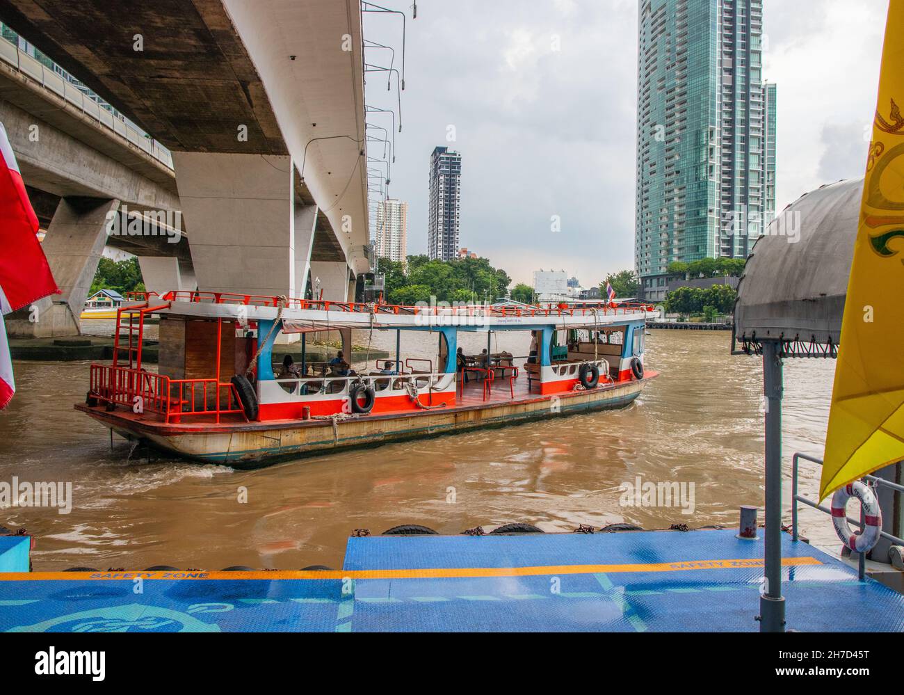 a ferry boat cross the Chao Phraya River at the Sathorn Pier in Bangkok ...