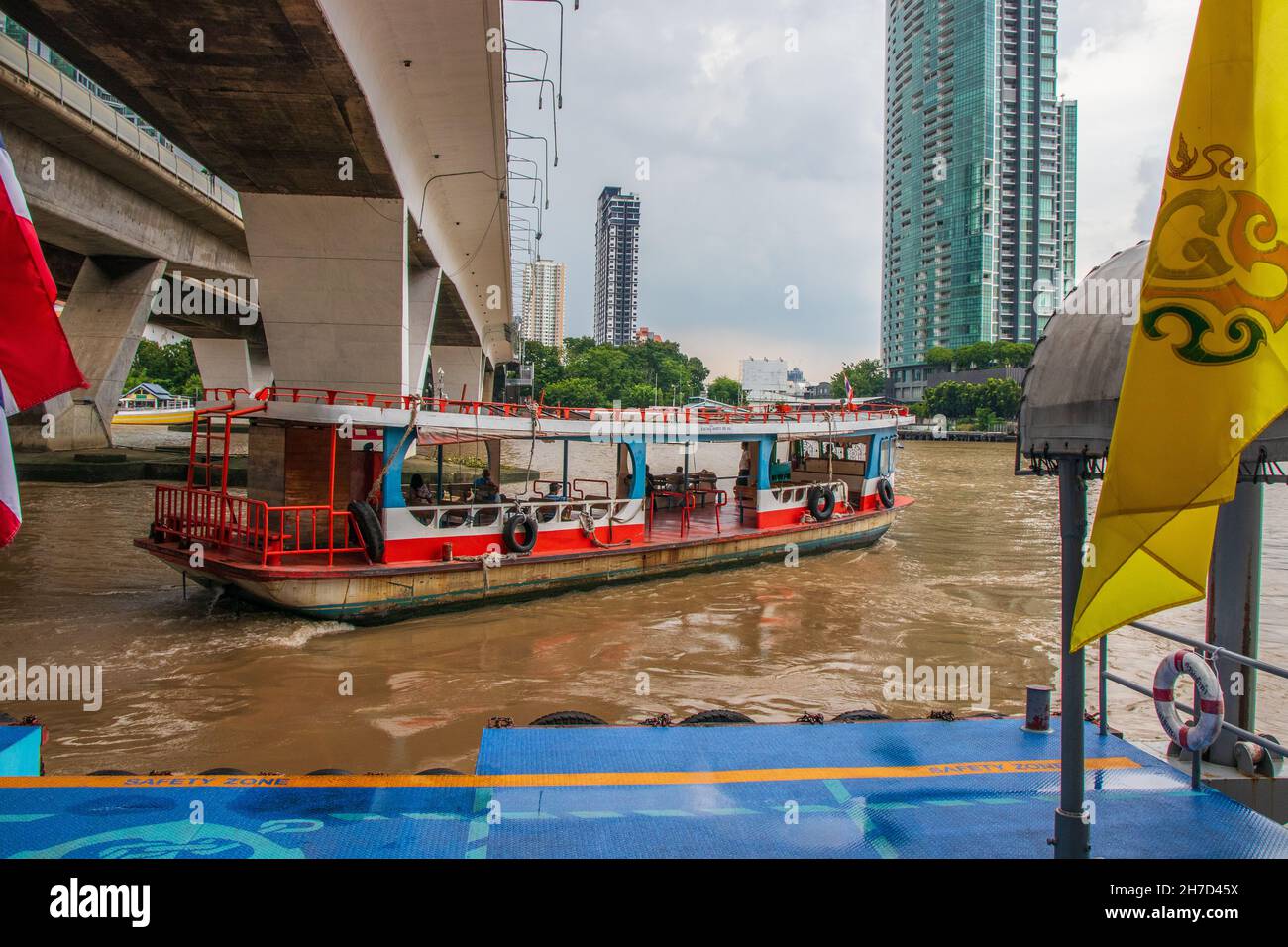 a ferry boat cross the Chao Phraya River at the Sathorn Pier in Bangkok ...