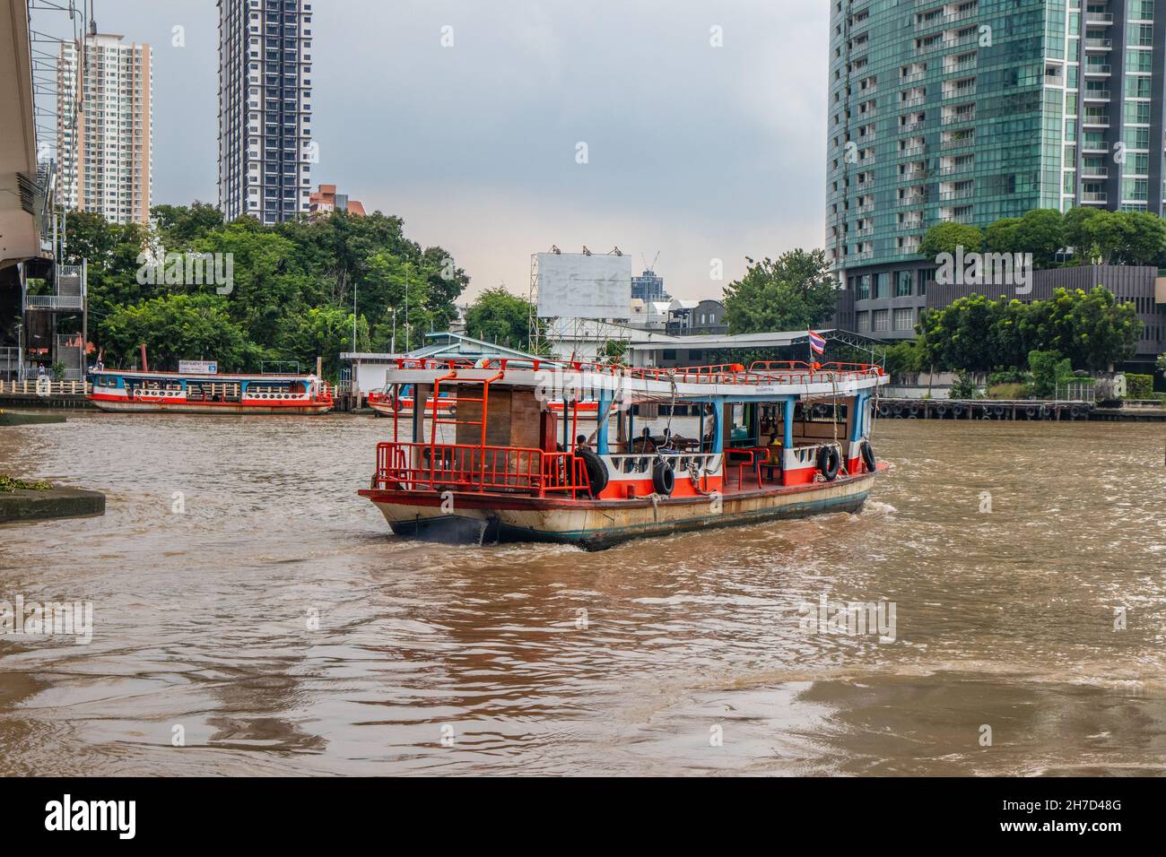 a ferry boat cross the Chao Phraya River at the Sathorn Pier in Bangkok ...