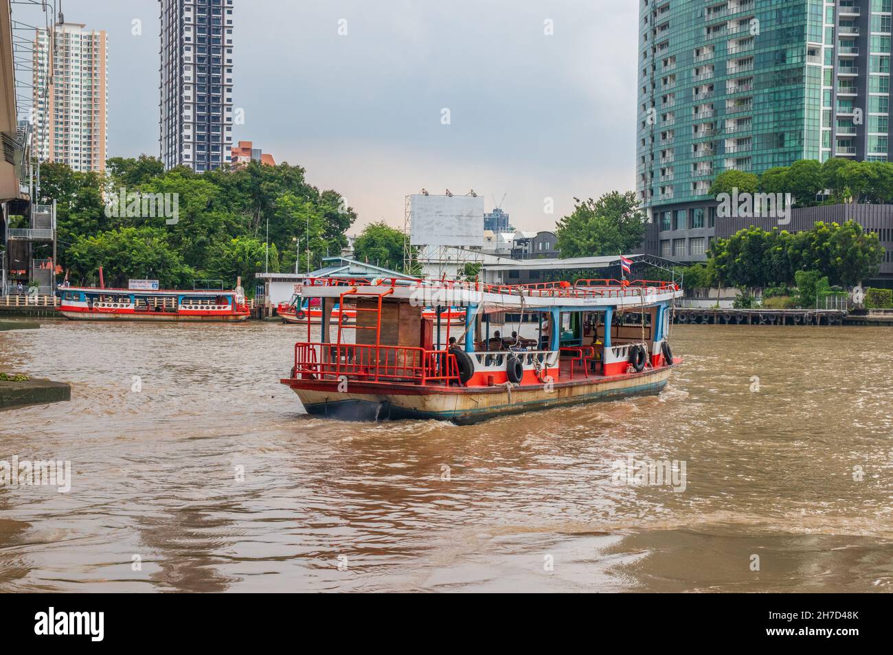 a ferry boat cross the Chao Phraya River at the Sathorn Pier in Bangkok ...