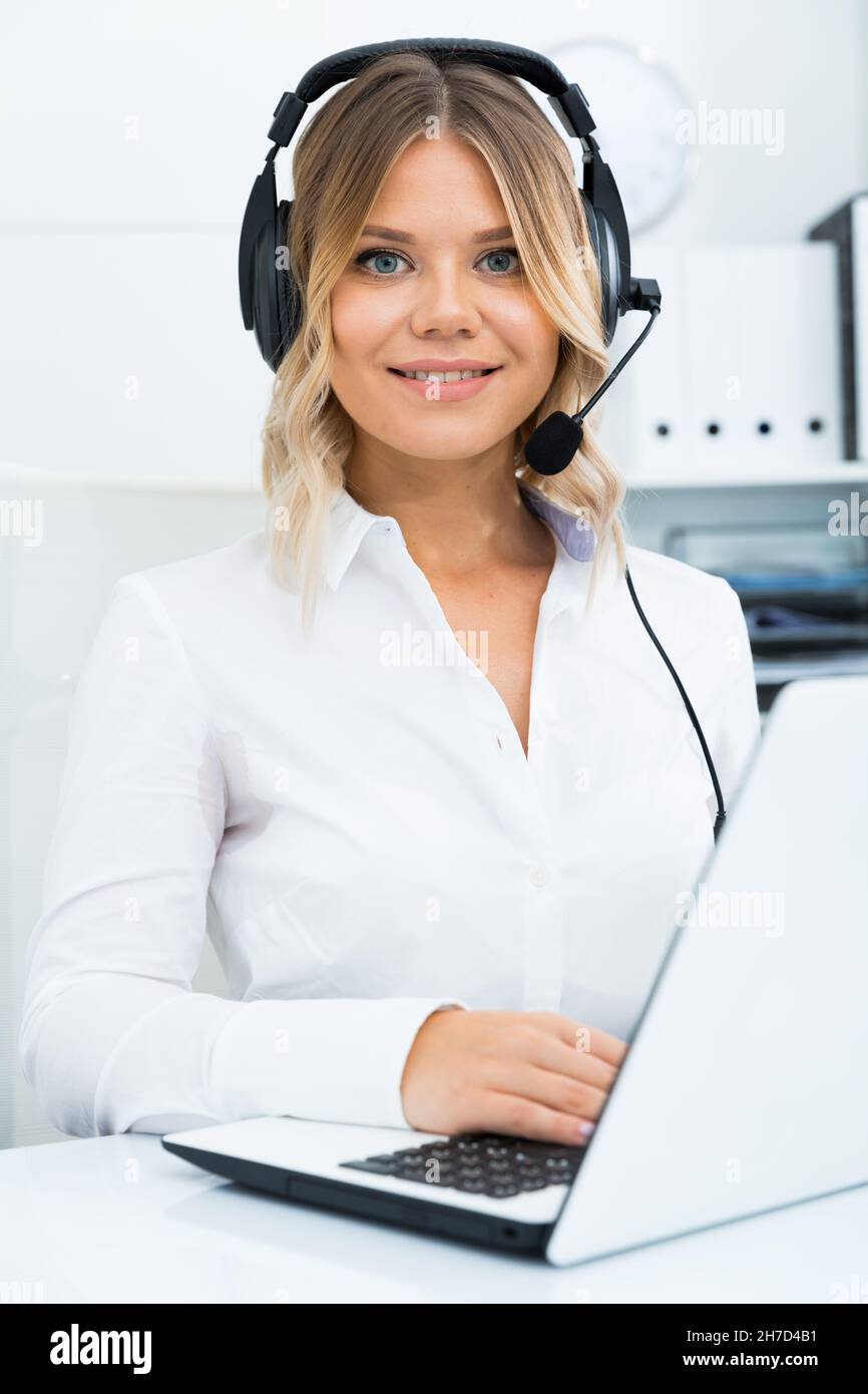 Young girl in call center with headphones sitting with laptop Stock ...