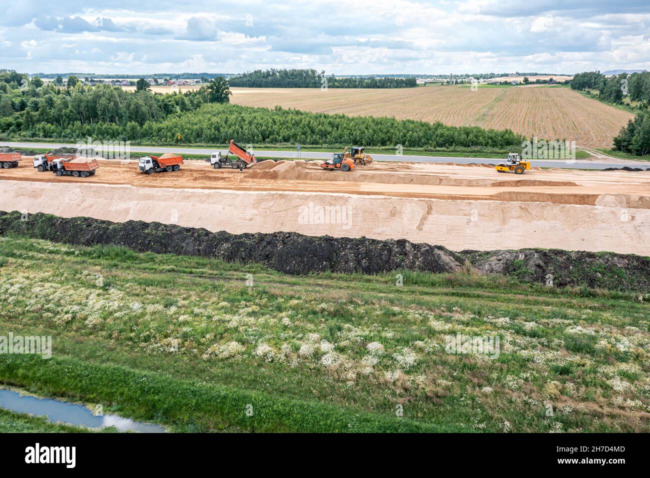 construction of new road in rural area. road rollers compacting and ...