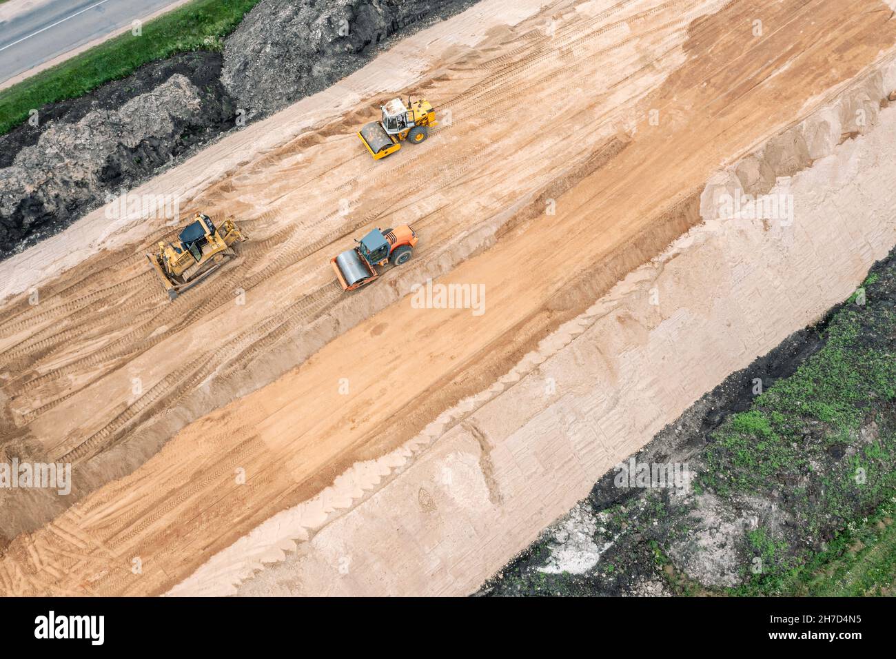 road rollers and bulldozer work on construction site. leveling the ...