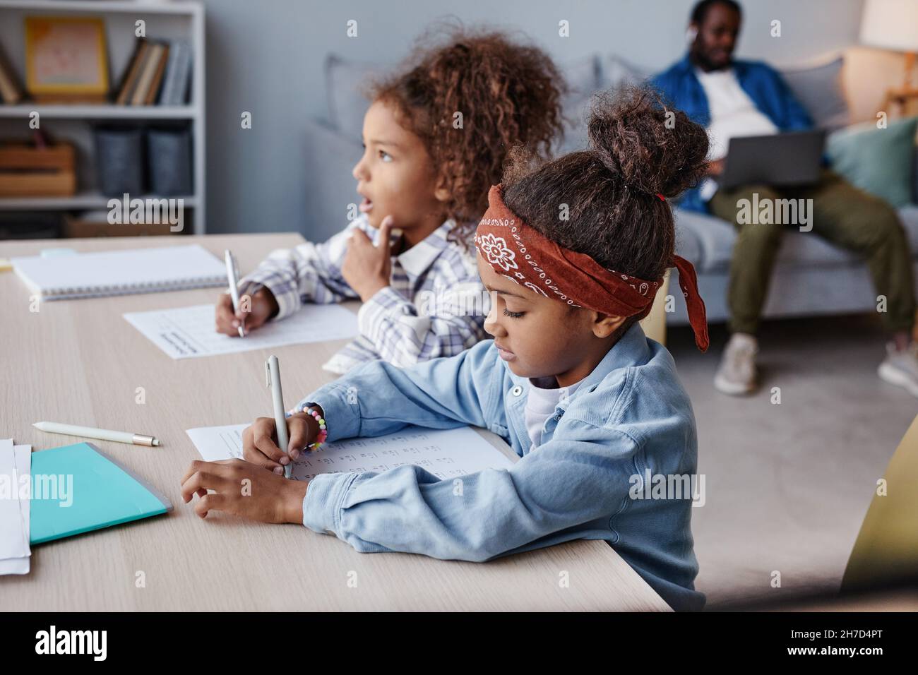 African american daughter doing homework table hi-res stock photography ...
