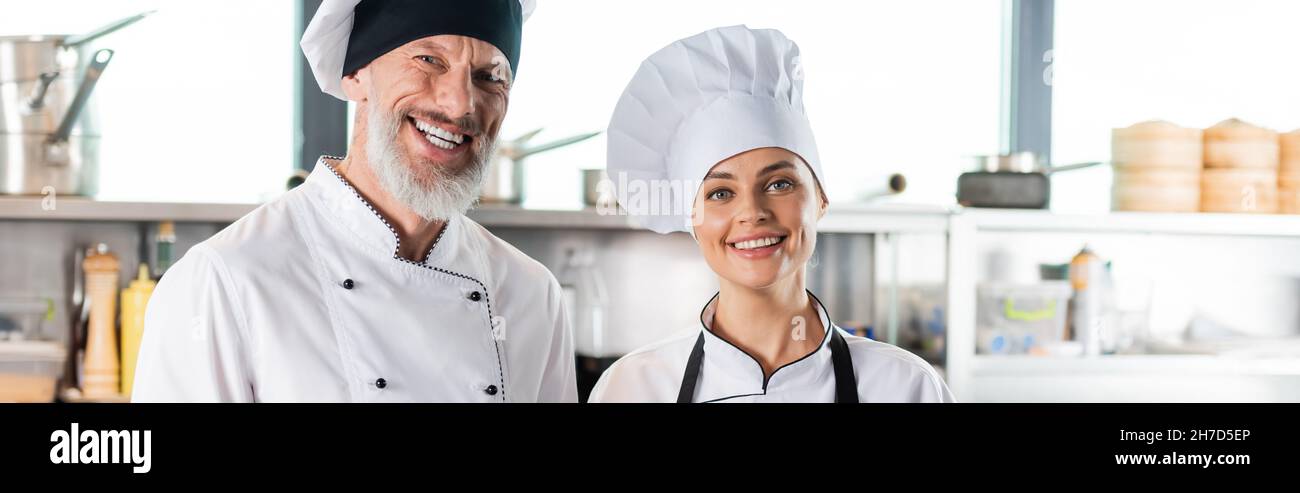 Positive chefs smiling at camera in restaurant kitchen, banner Stock ...