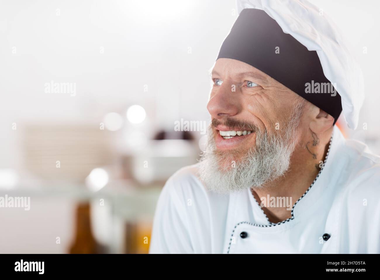 Portrait of smiling chef looking away in kitchen Stock Photo - Alamy