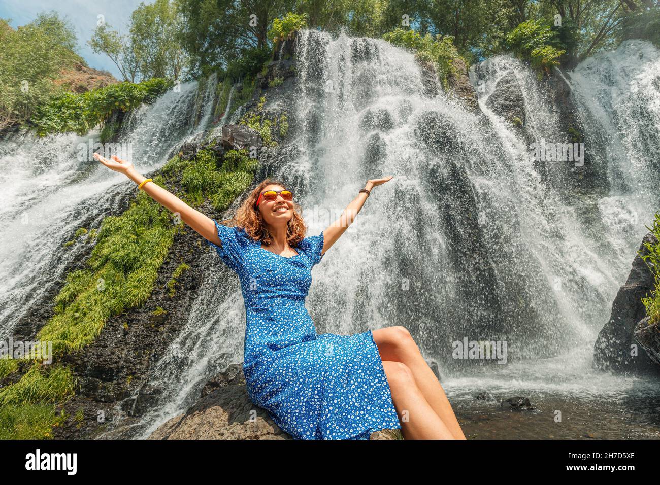 A happy female traveler is resting near the beautiful and large Shaki ...
