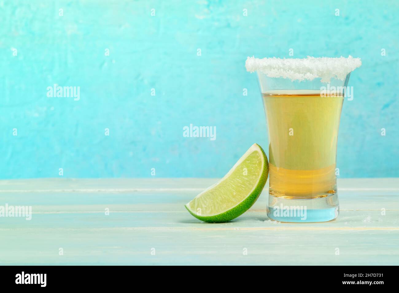 Tequila shot with a lime slice, a Mexican alcohol drink on a turquoise ...
