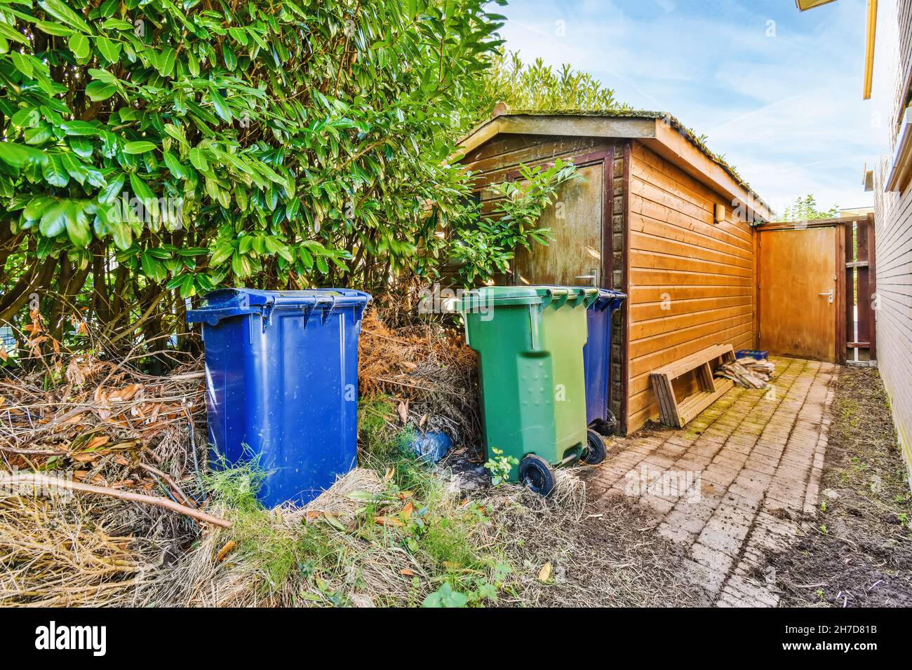 A wooden gate leading to the place with trash cans Stock Photo - Alamy
