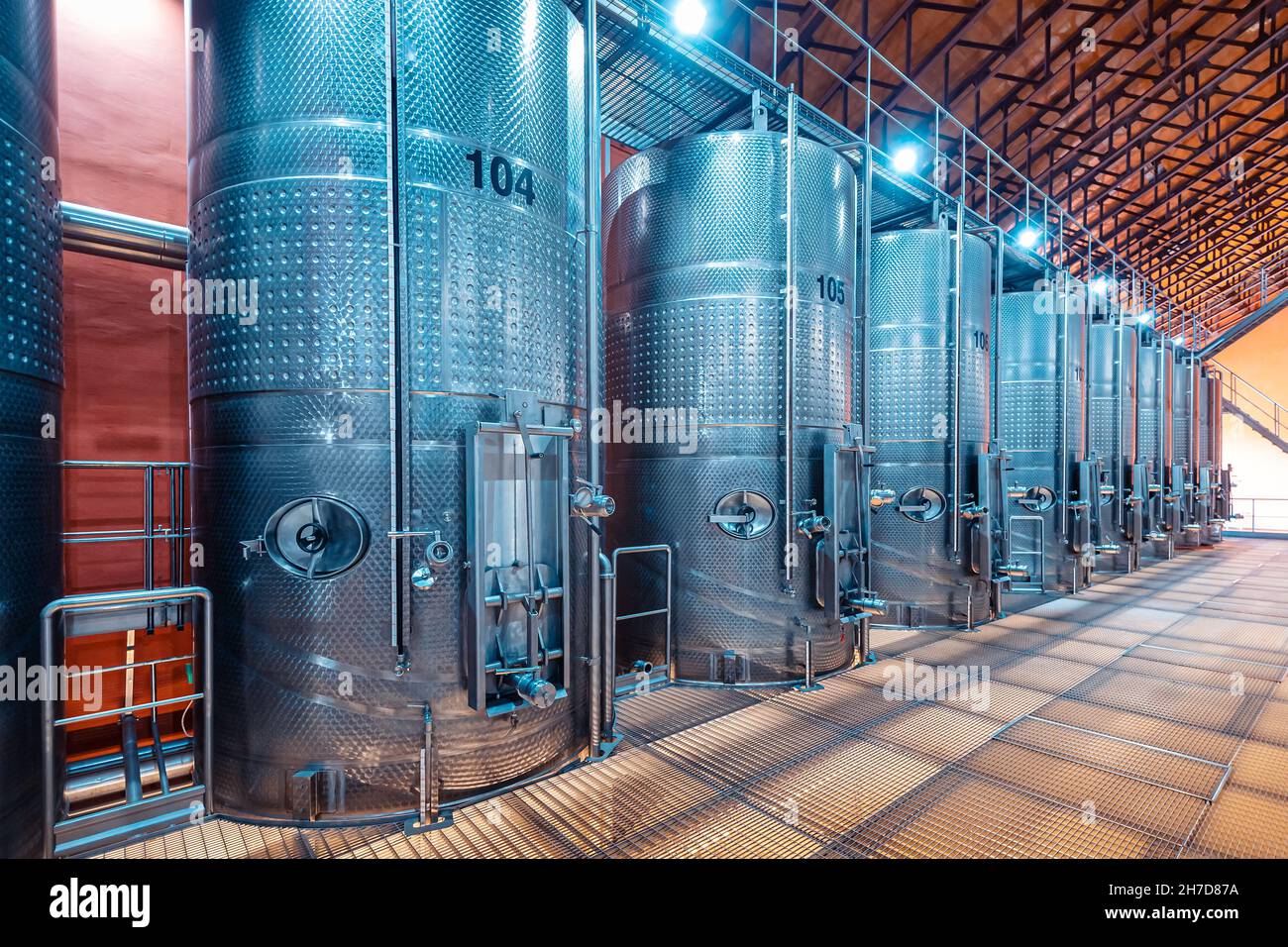 Large metal vats in which wine or beer is fermented at the factory at ...