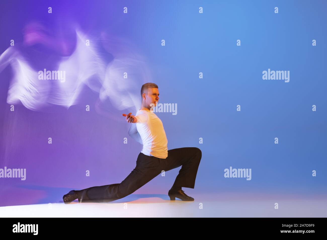 Portrait of young male ballroom dancer dancing alone isolated on ...