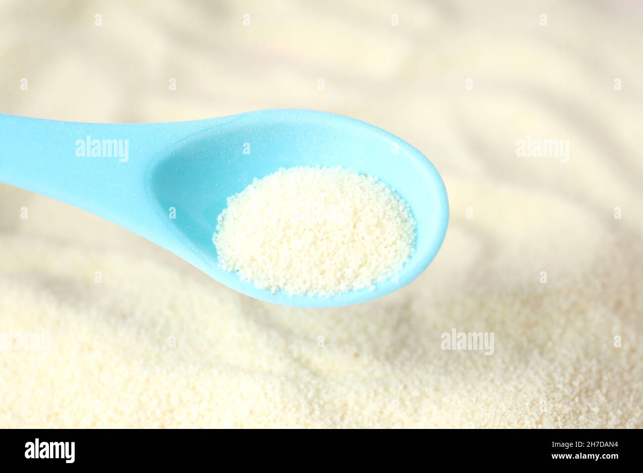 Blue plastic spoon with powdered milk, close up Stock Photo - Alamy