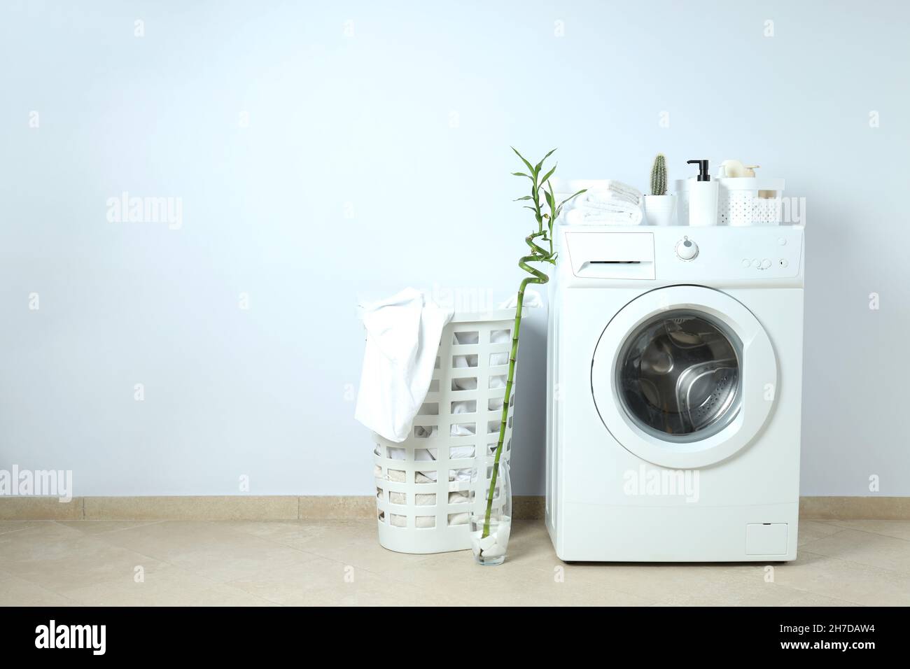 Concept of housework with washing machine against white wall Stock ...