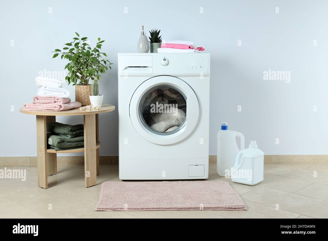 Concept of housework with washing machine against white wall Stock ...