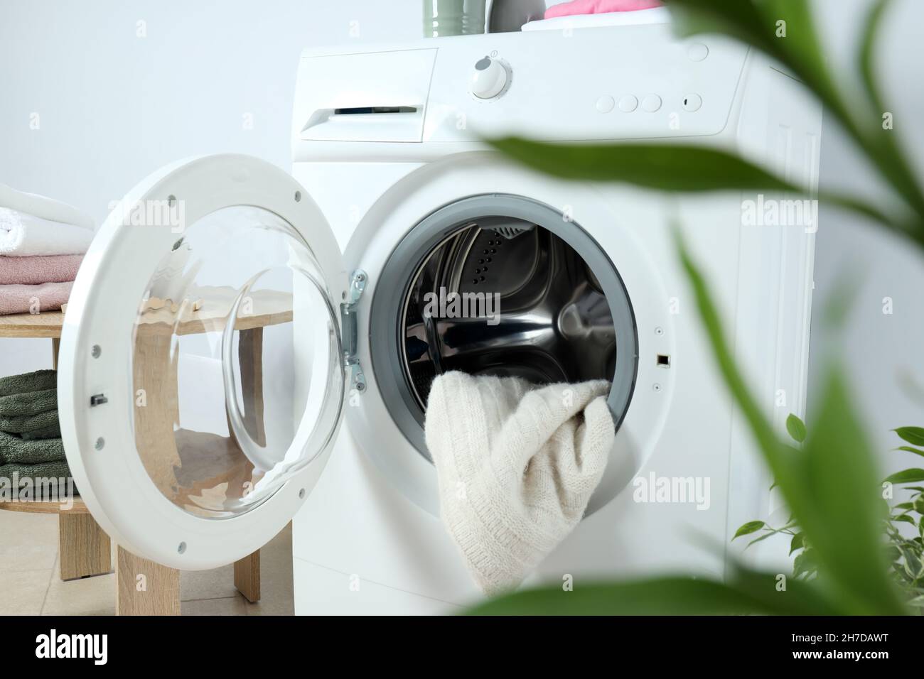 Concept of housework with washing machine against white wall Stock ...