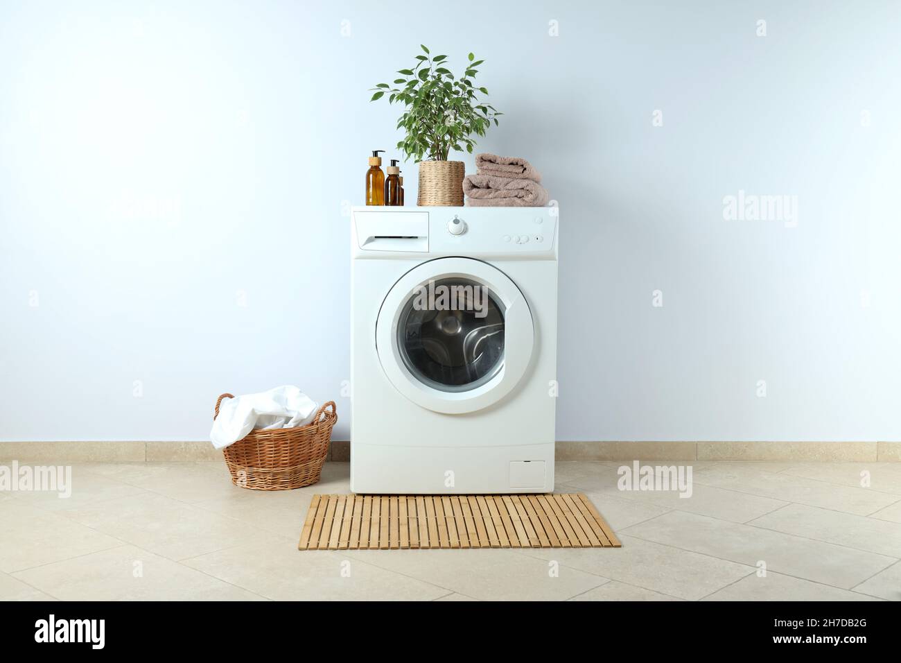 Concept of housework with washing machine against white wall Stock ...