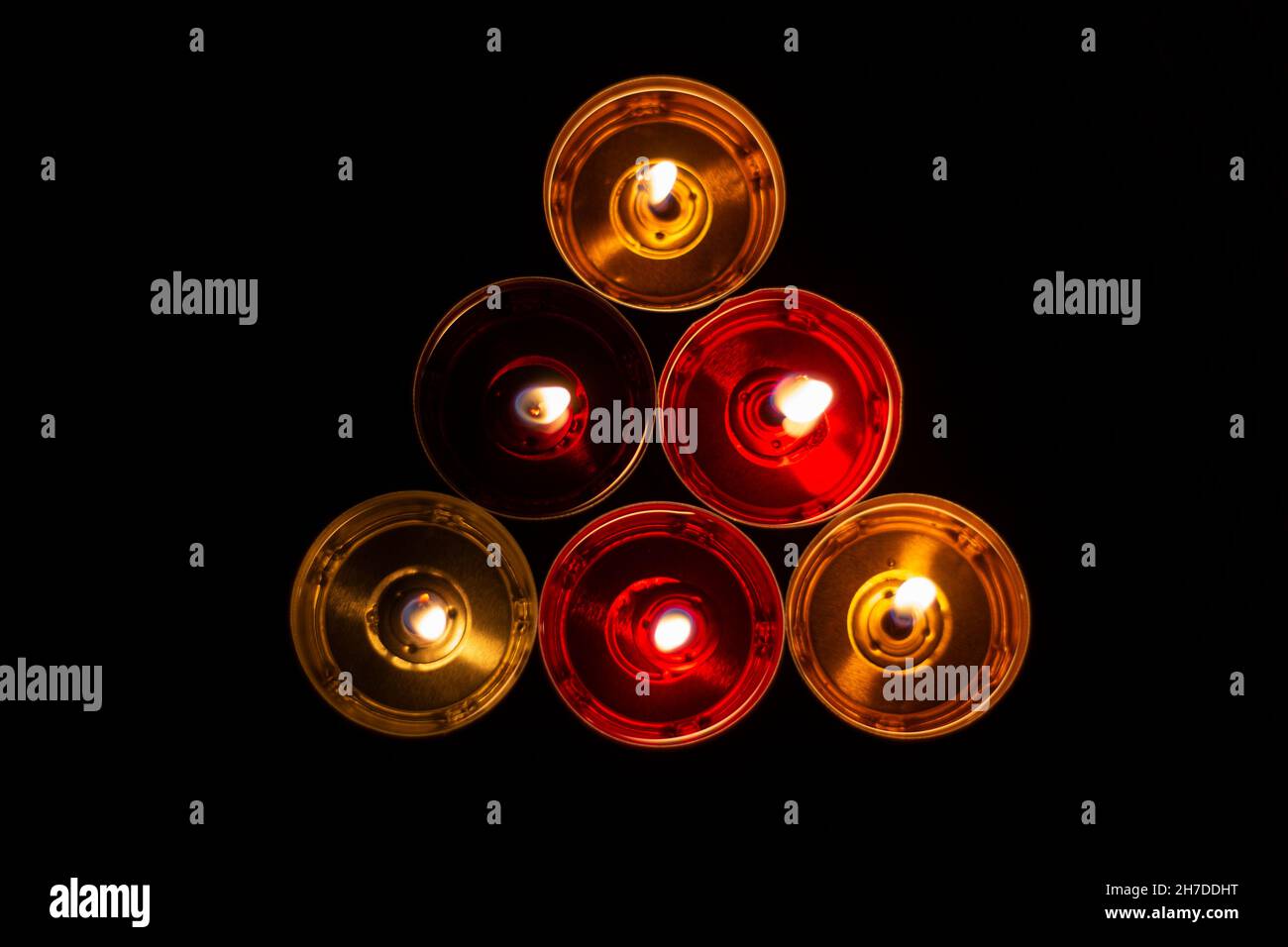 The candles are laid out in a triangle. Candles burn in the dark. Red ...