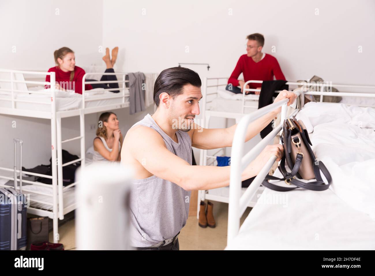 Man climbing up to top bunk of bunk bed in hostel Stock Photo - Alamy
